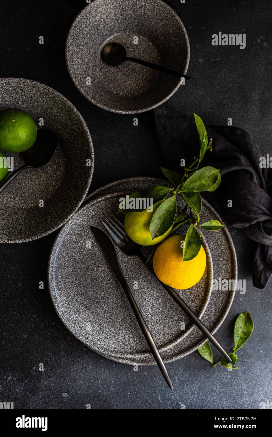 A sophisticated table setting featuring gray ceramics, fresh citrus ...
