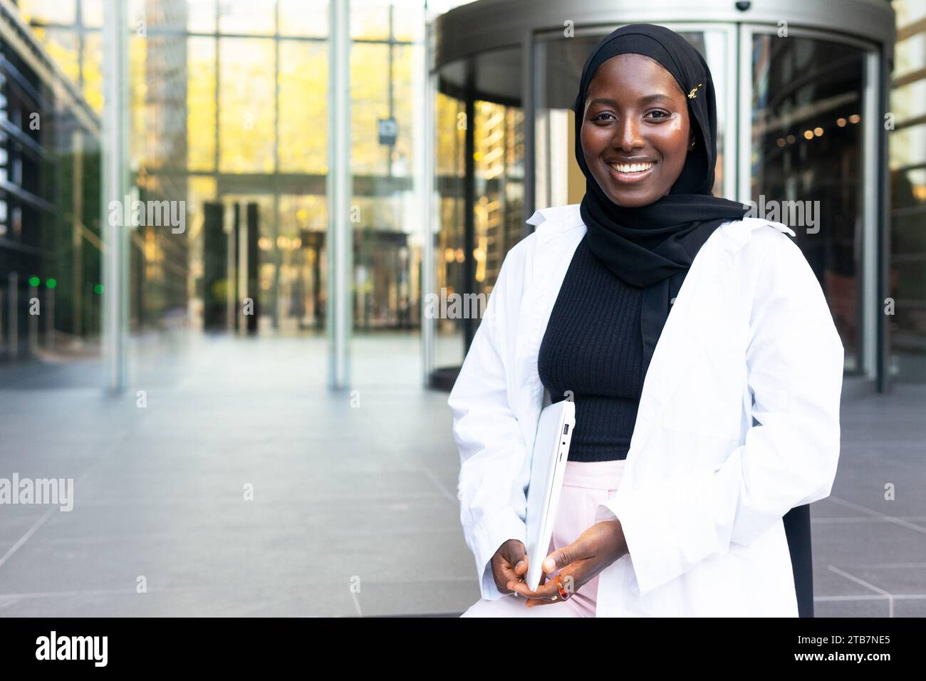 Cheerful Muslim African American female entrepreneur dressed in hijab ...