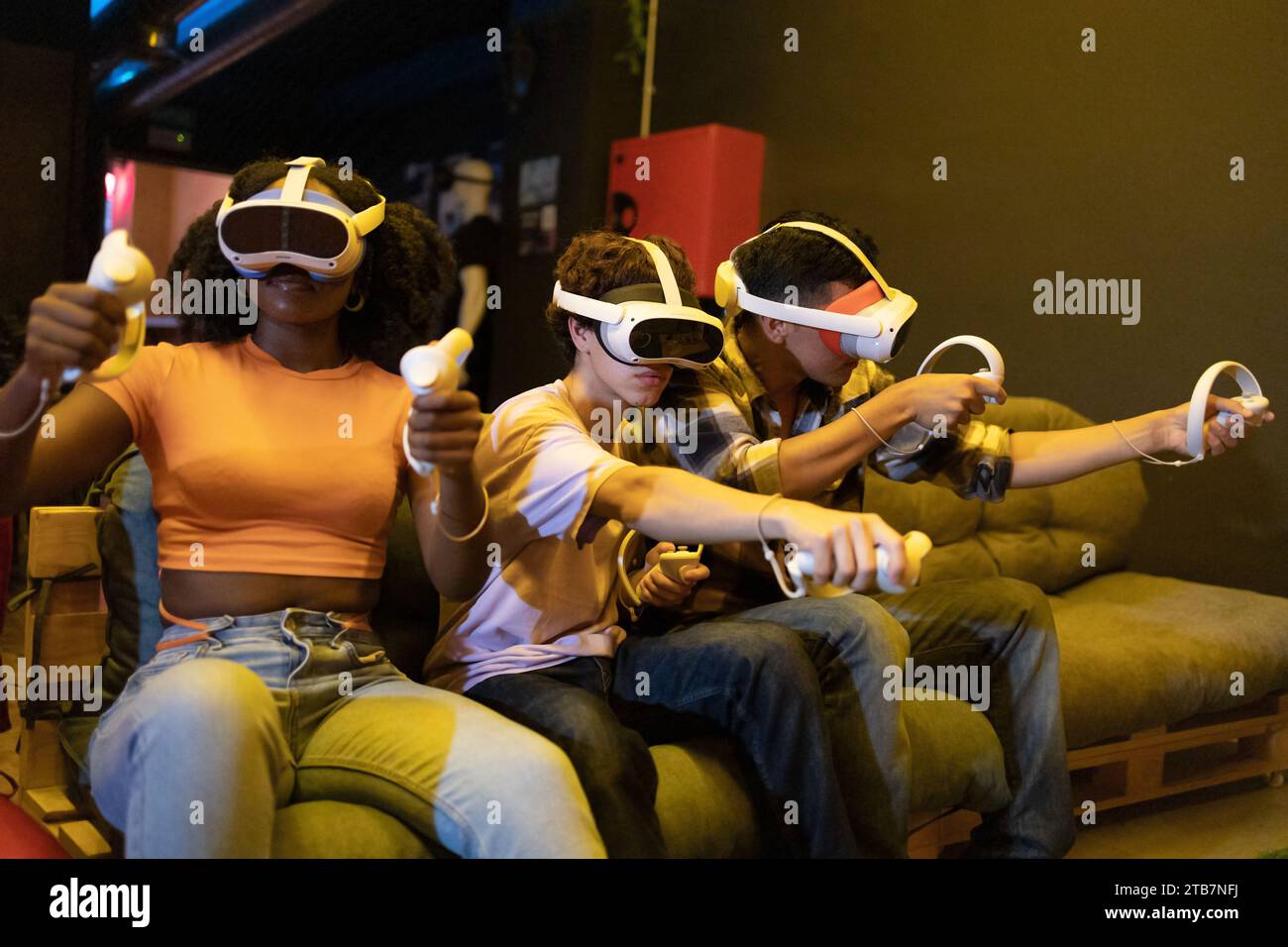 Multiethnic friend engrossed in a virtual reality game wearing VR ...