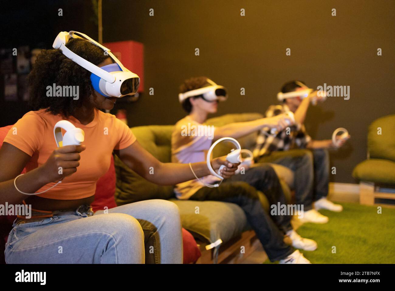 Multiethnic friend engrossed in a virtual reality game wearing VR ...