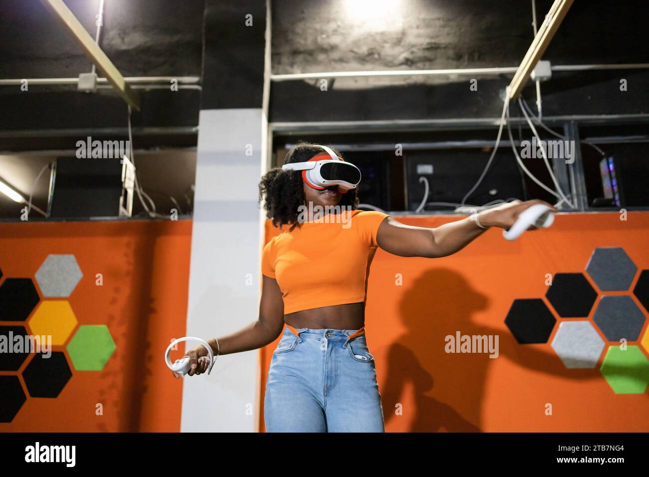 A young woman is fully engaged with a virtual reality headset and ...