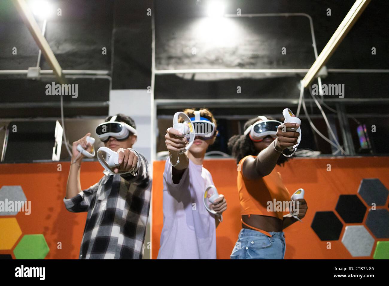 Young multiracial friends fully immersed in a virtual reality gaming ...