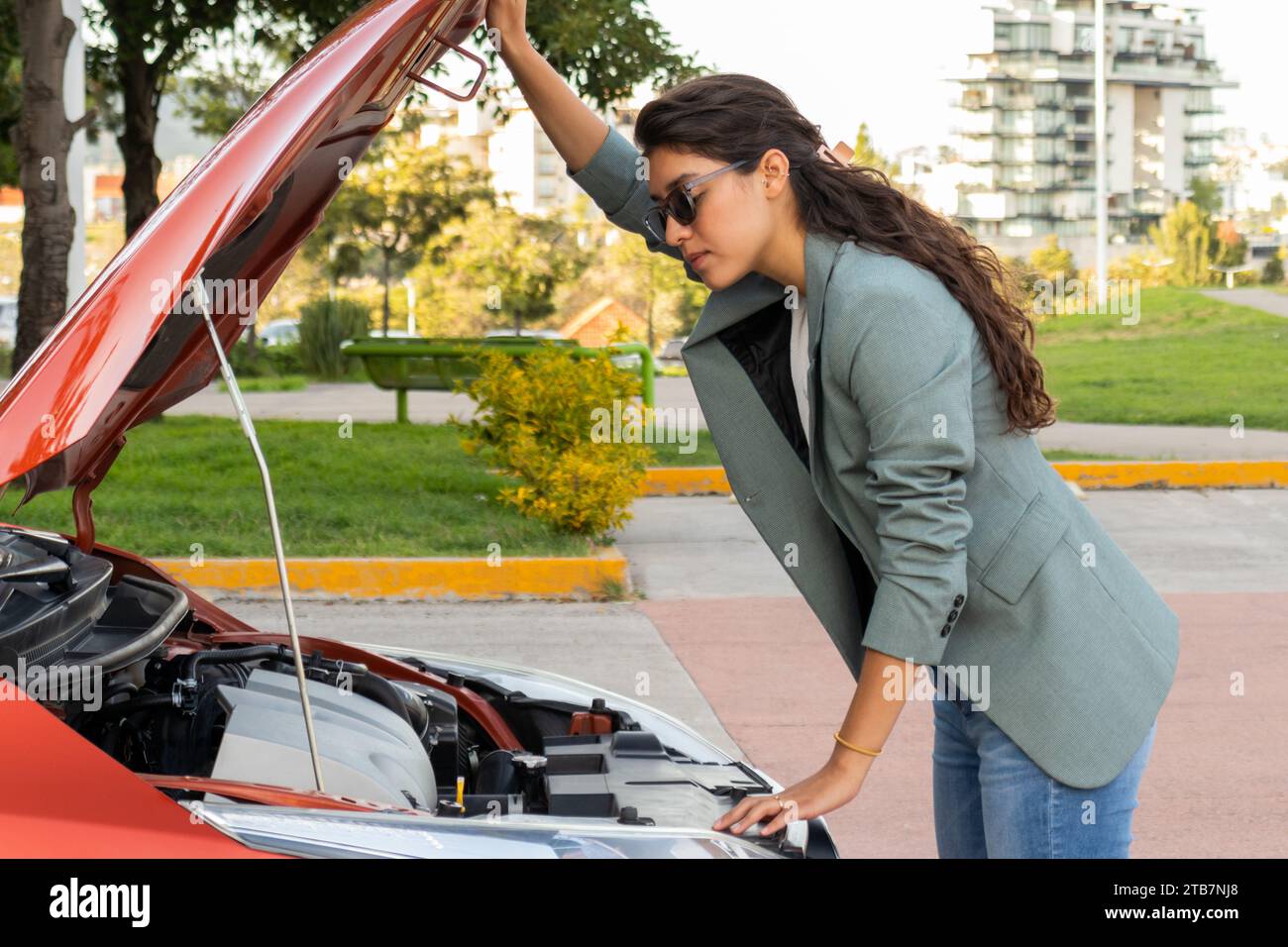 Confident serene young female entrepreneur dressed in blazer examining ...