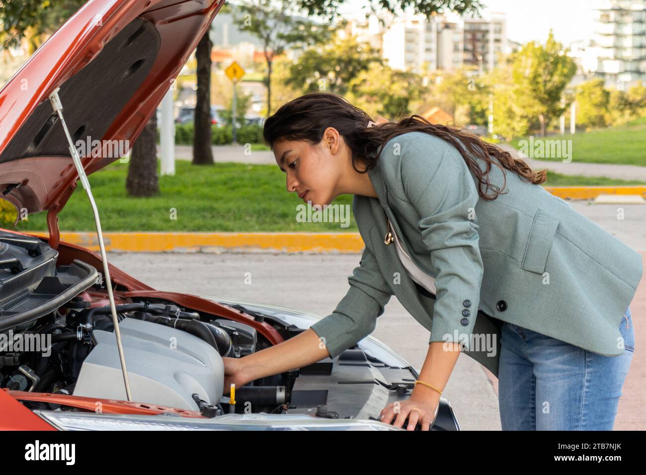 Confident serene young female entrepreneur dressed in blazer examining ...