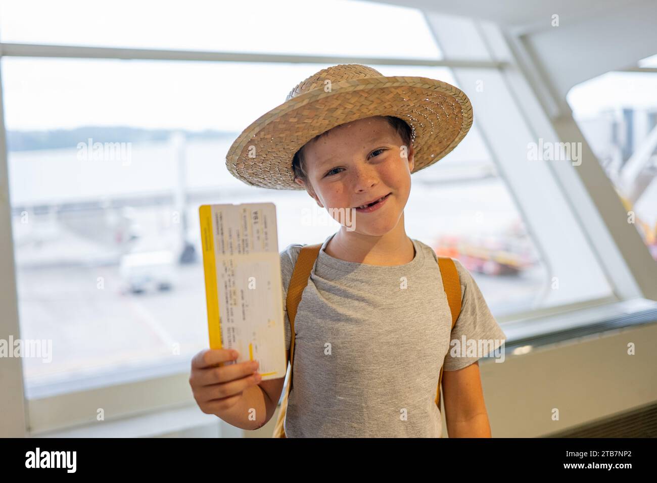 Portrait of cute smiling boy in casuals and straw hat standing at ...