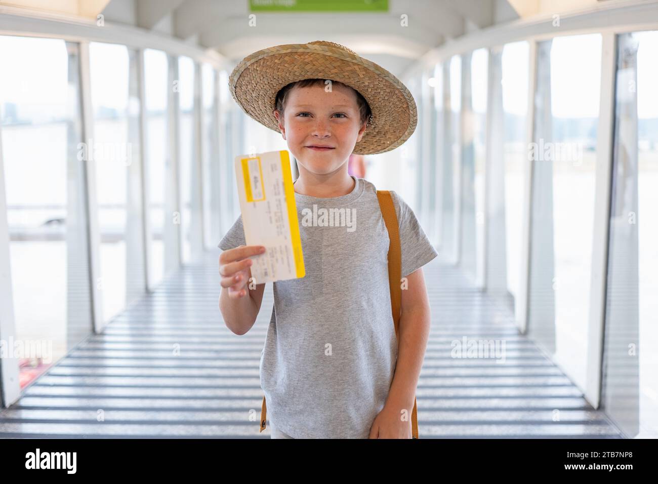 Portrait of cute smiling boy in casuals and straw hat standing at ...