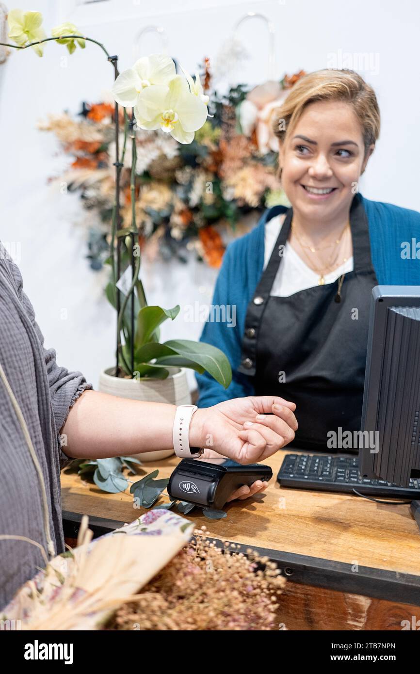 Close up of cropped unrecognizable person paying with a smartwatch at a ...