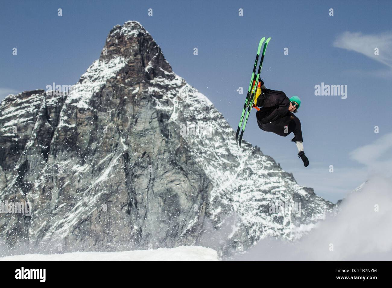 Full body of active person jumping with snowboard above snowy mountain ...