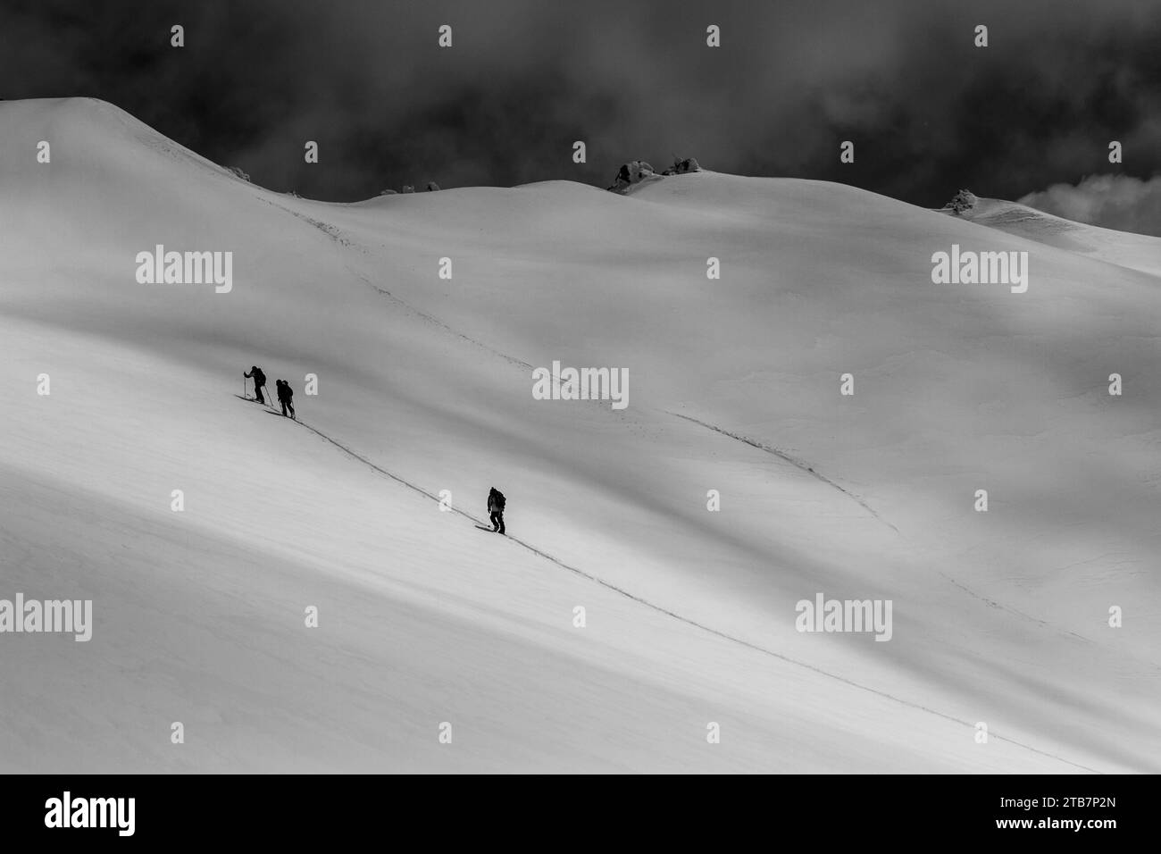 Full body of unrecognizable adventures people climbing on snowcapped ...