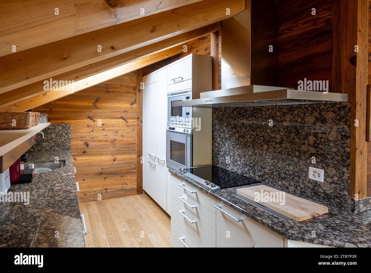 A modern kitchen nestled in an attic space featuring rustic wooden ...