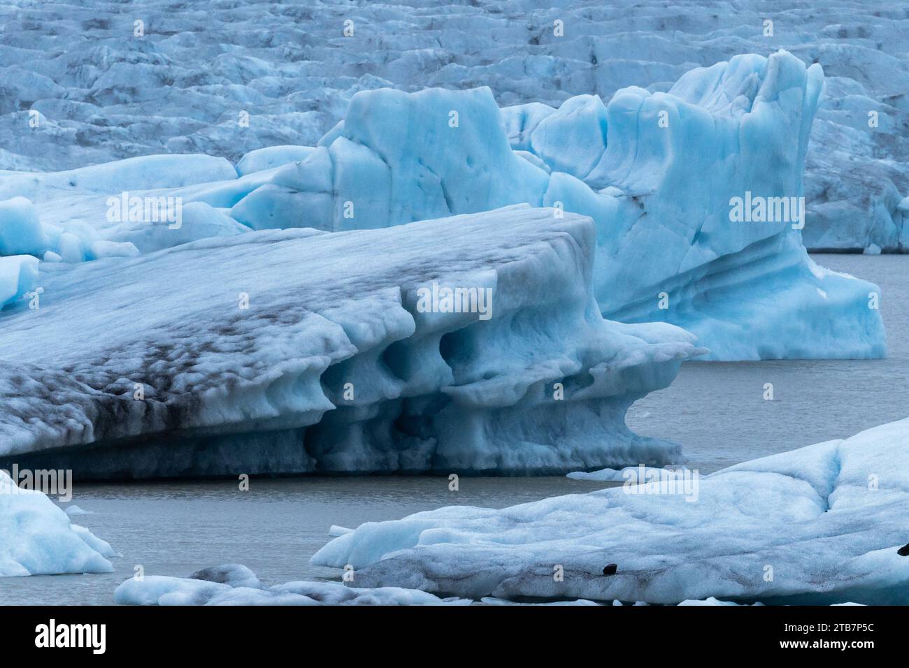 Striking blue ice formations stand amidst the chilly waters in the ...