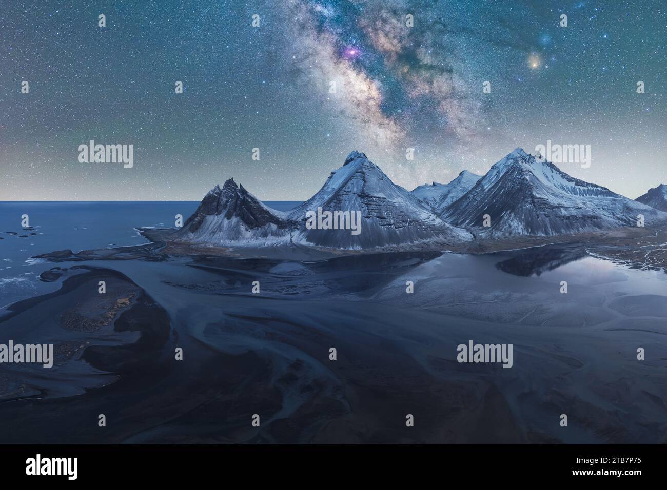 A serene night sky filled with the Milky Way's radiant sweep overlooks ...