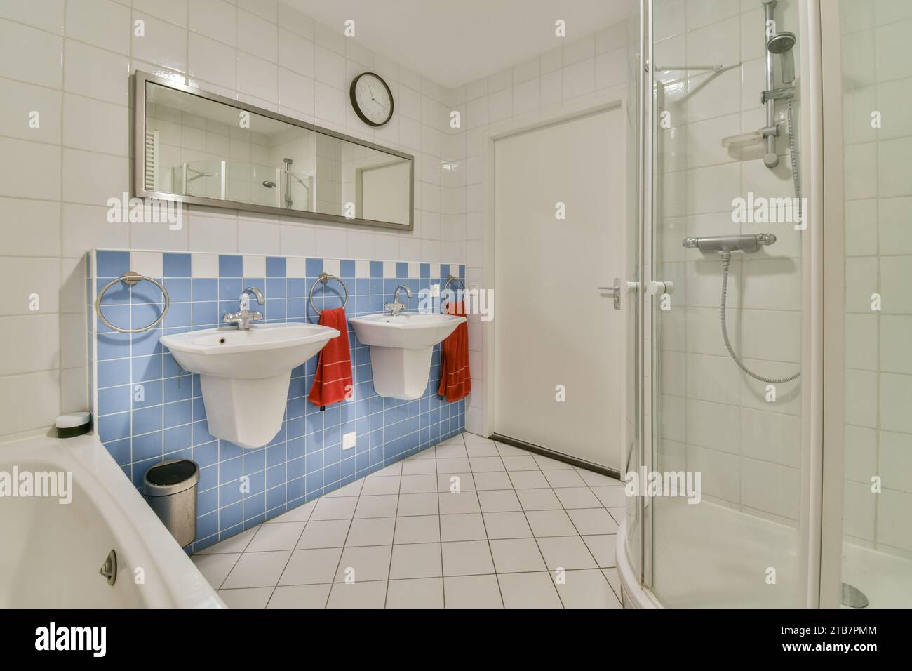Shower booth with glass wall by two sinks and bathtub in spacious ...