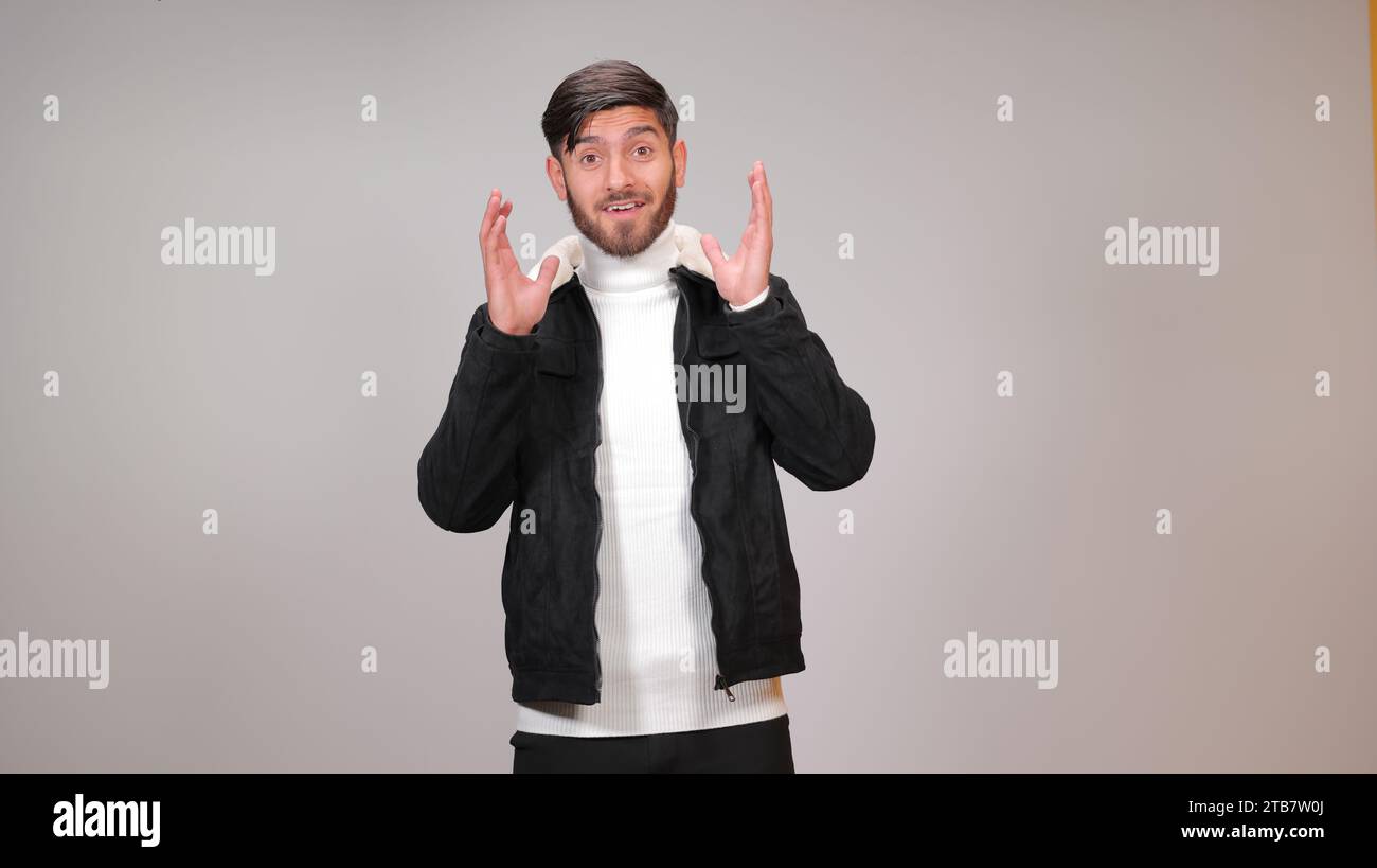A young man striking a surprised pose against a gray background Stock ...