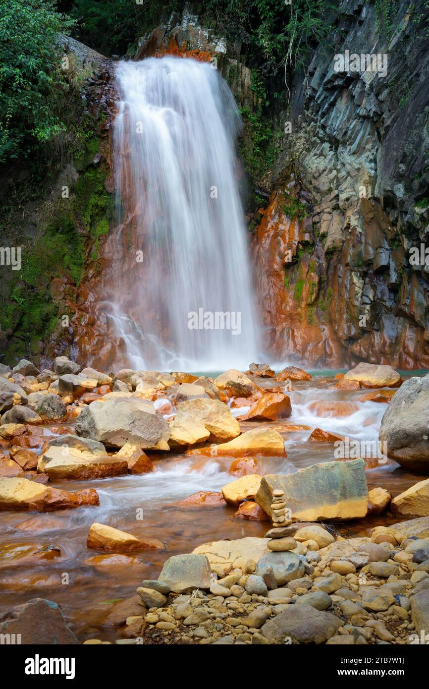 The Red Rocks waterfall cascading over a rugged landscape of rocks in ...
