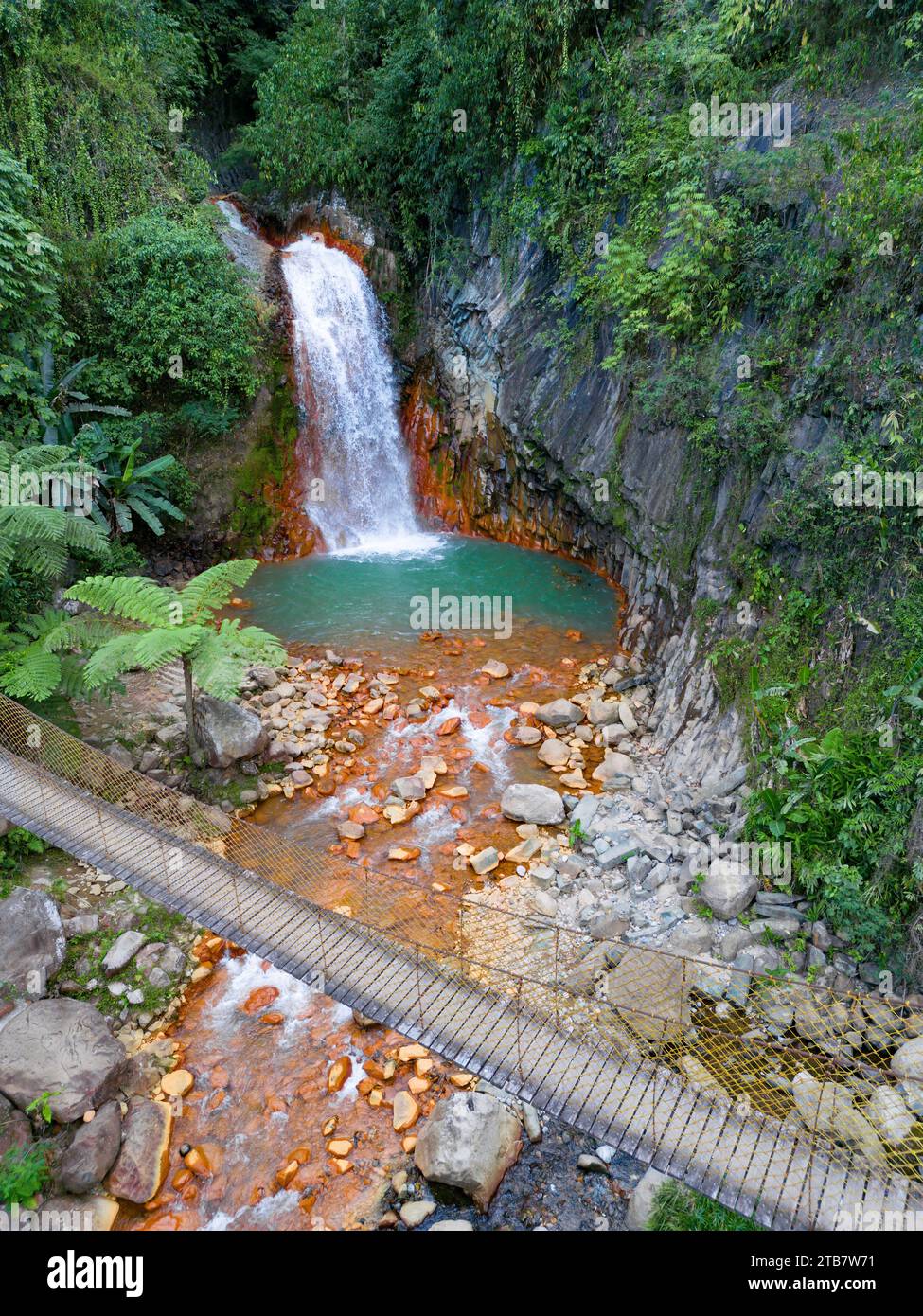 The Red Rocks waterfall cascading over a rugged landscape of rocks in ...