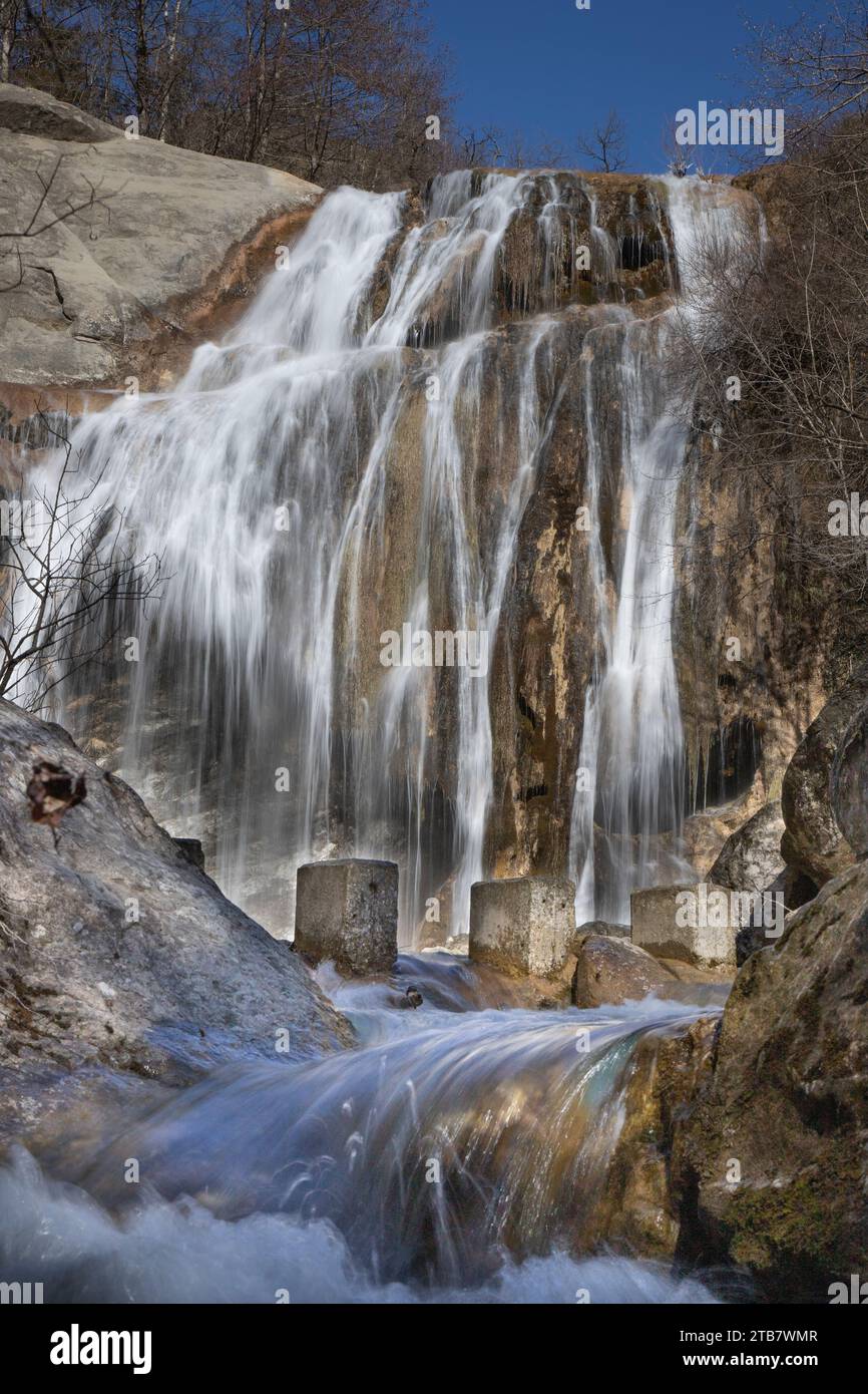 A magnificent waterfall cascading down the side of a rugged rocky ...