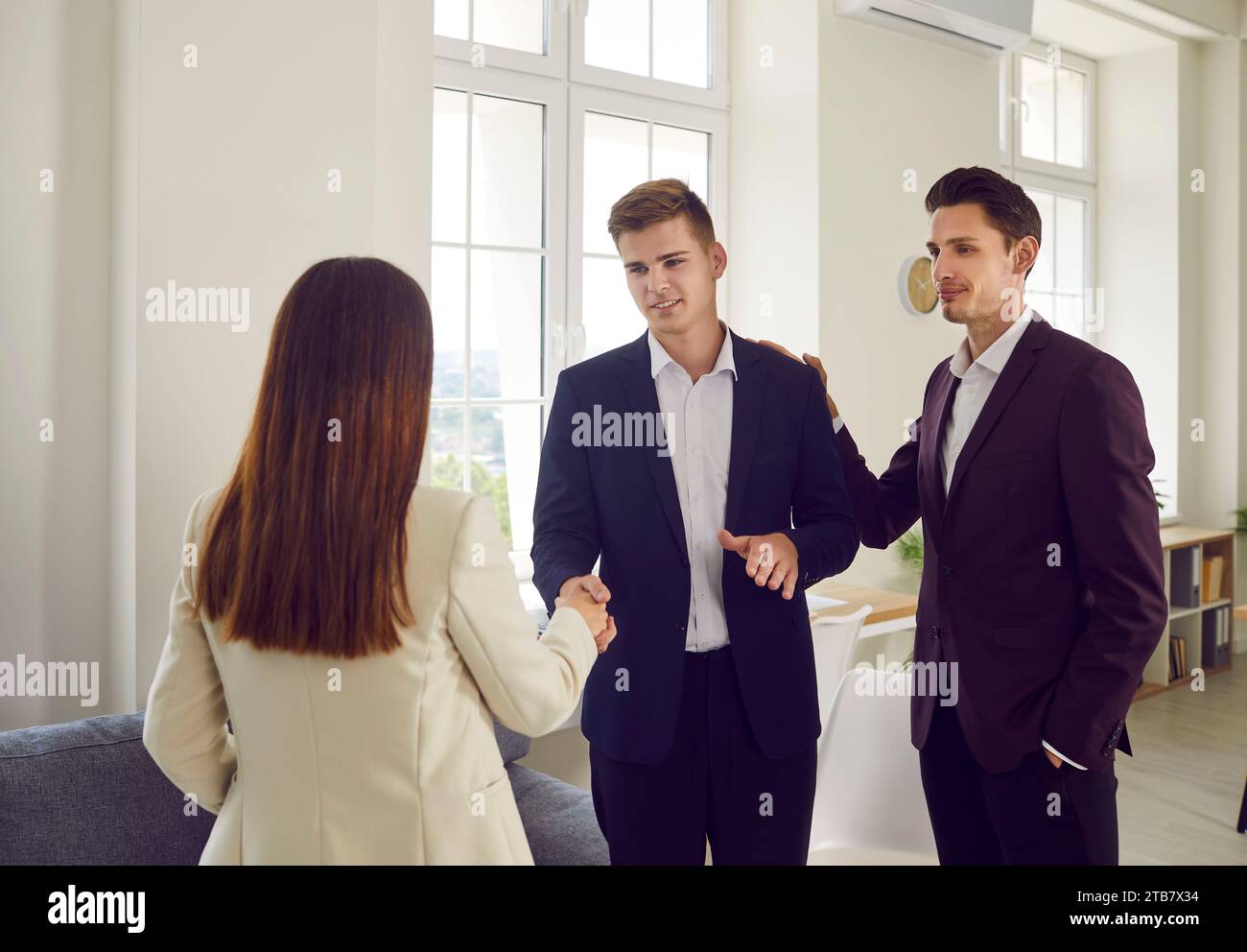 Business people standing in office making a deal. Man shaking hands ...