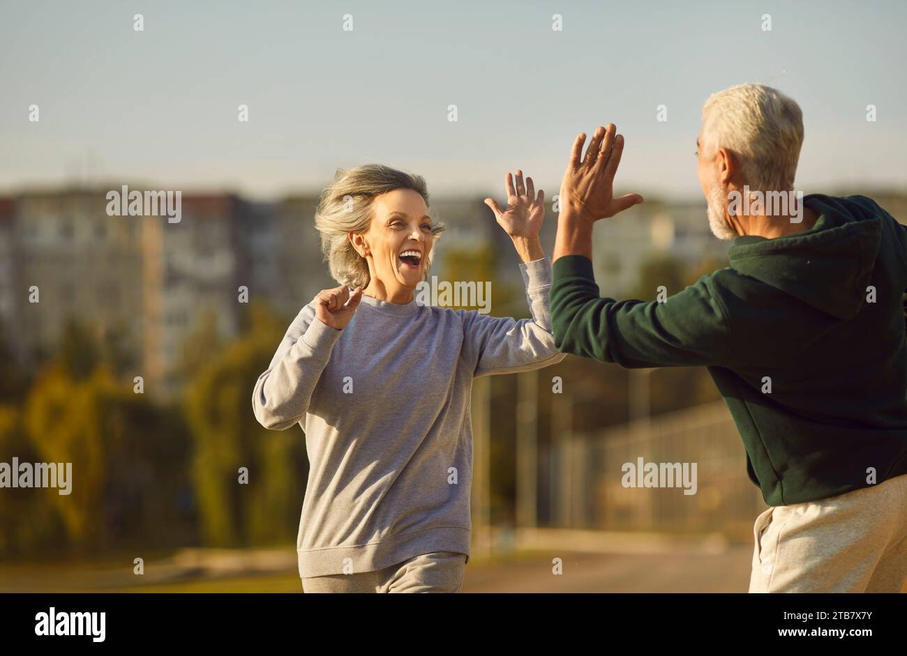 Senior couple giving high five to each other after workout or jogging ...