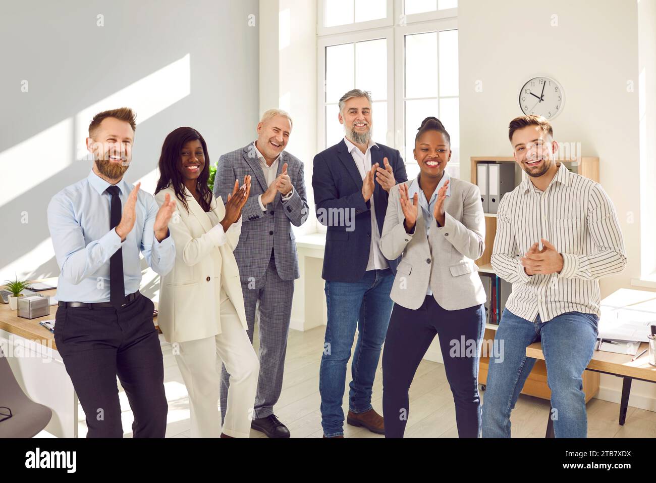 Team of happy diverse business people standing in office, clapping ...