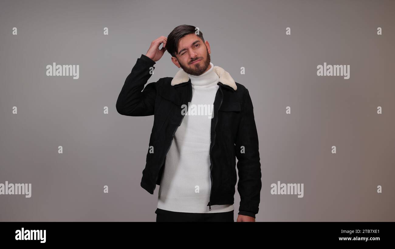 A confused young man thinking against a gray background Stock Photo - Alamy
