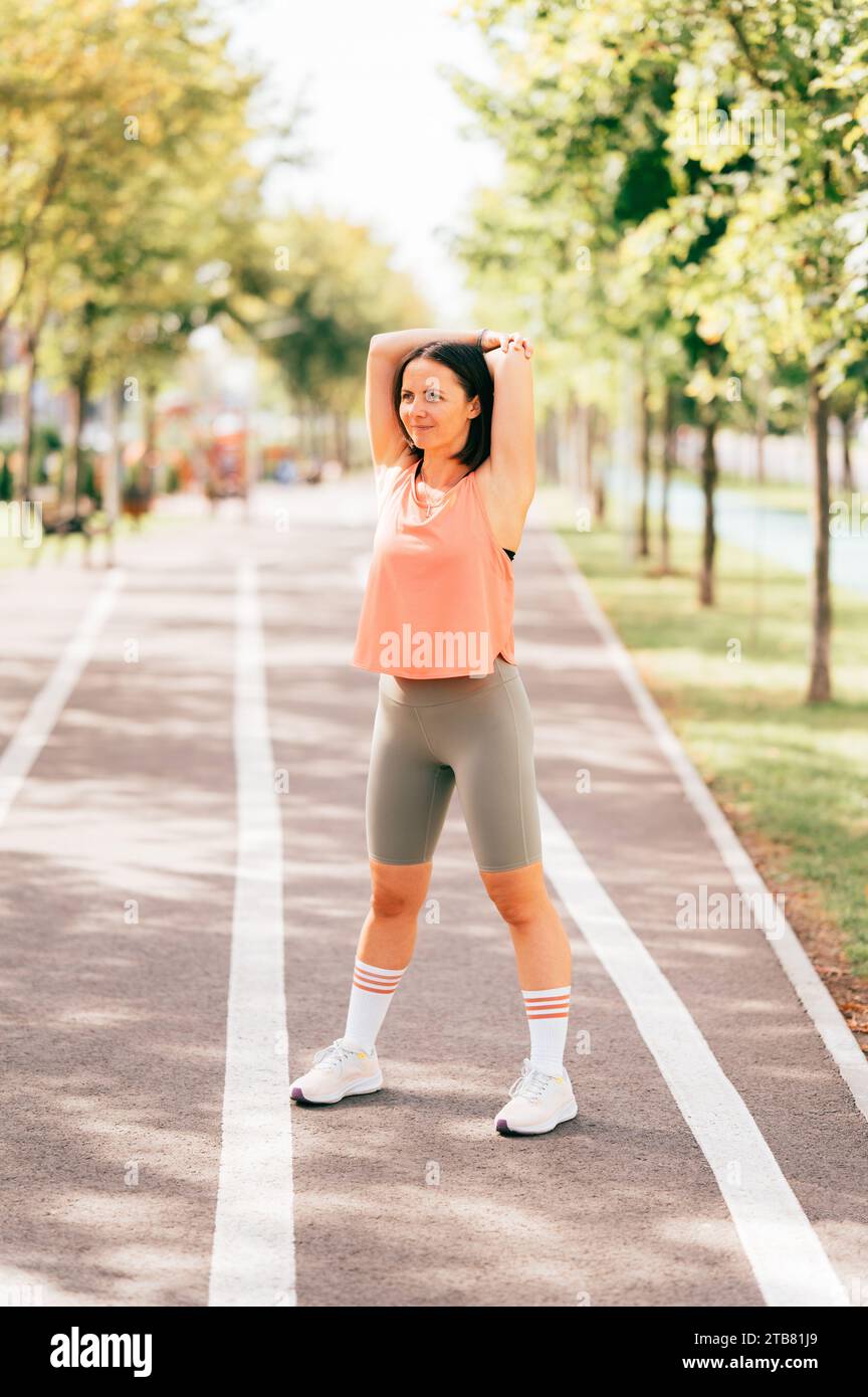 Vertical image of sport woman making her morning stretching routine ...