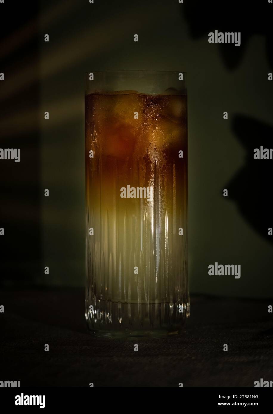 Dark and Stormy highball cocktail with ice and lime in front of green background Stock Photo - Alamy