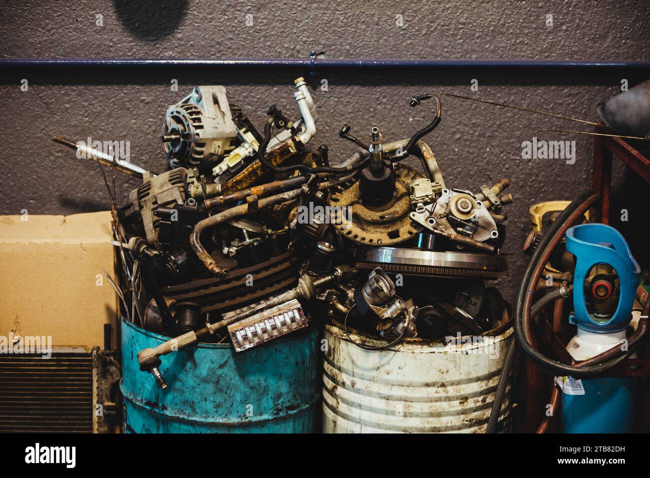 Car engine parts in a container for recycling in a car workshop ...