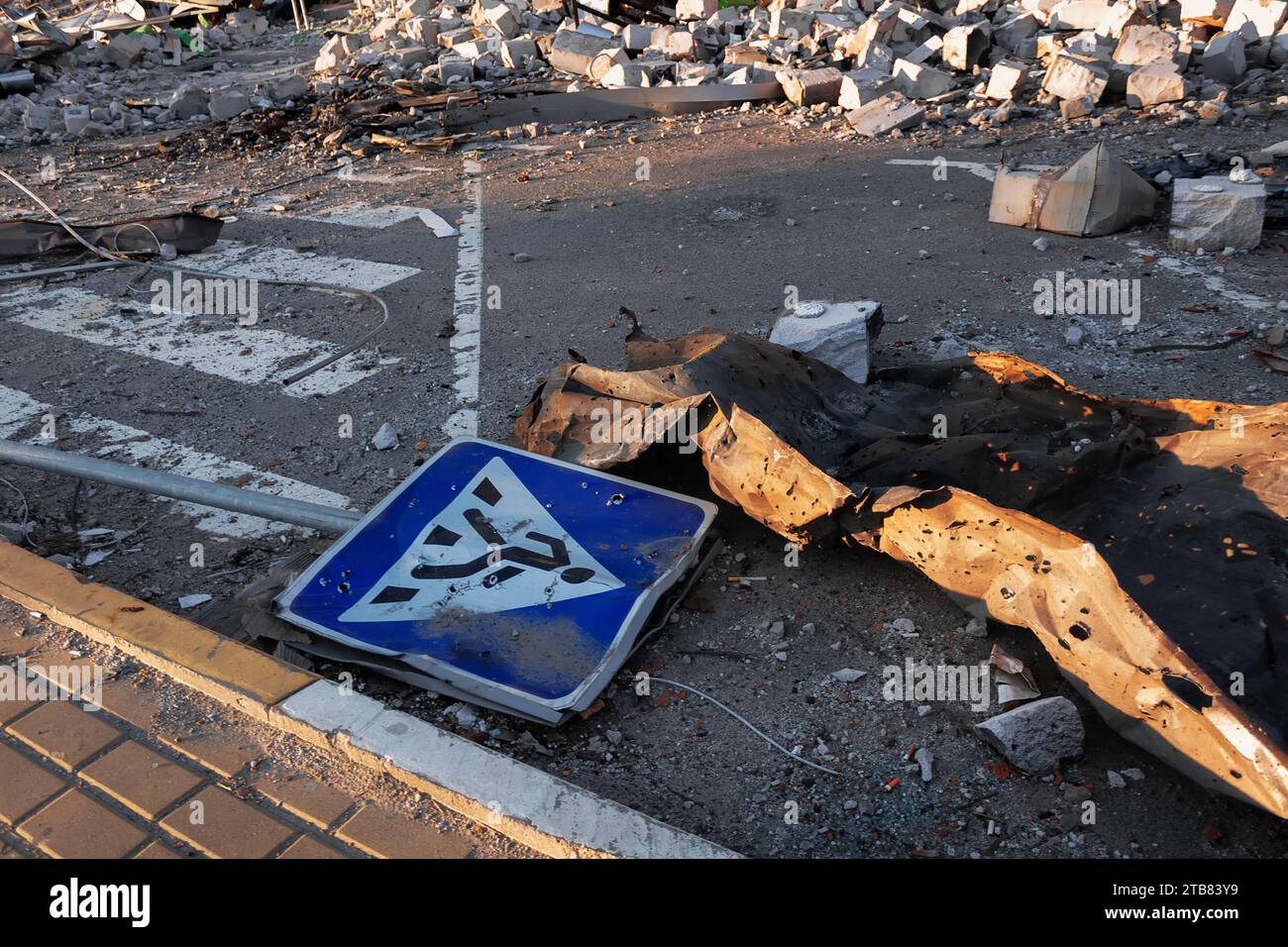 Pedestrian sign lying near ruined shopping mall as a result of mortar ...