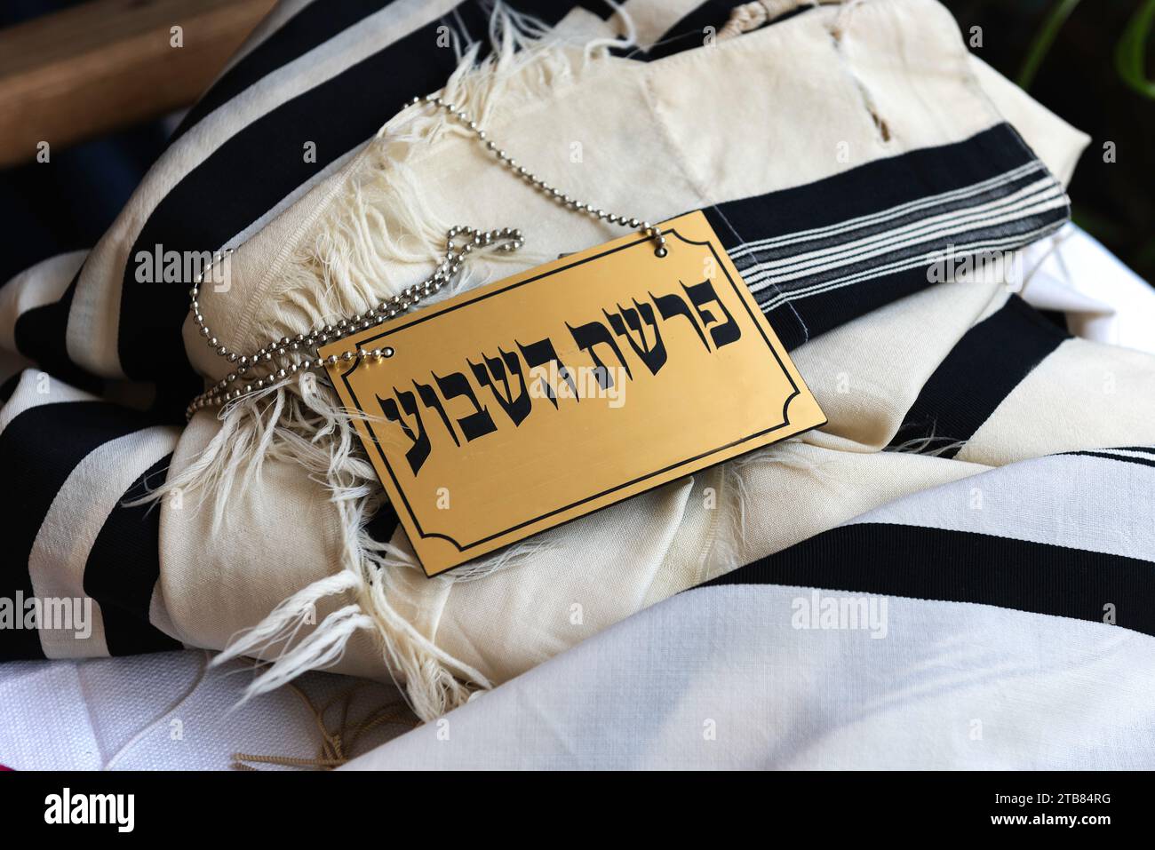 A black and gold sign in Hebrew which reads, "the weekly Torah portion ...