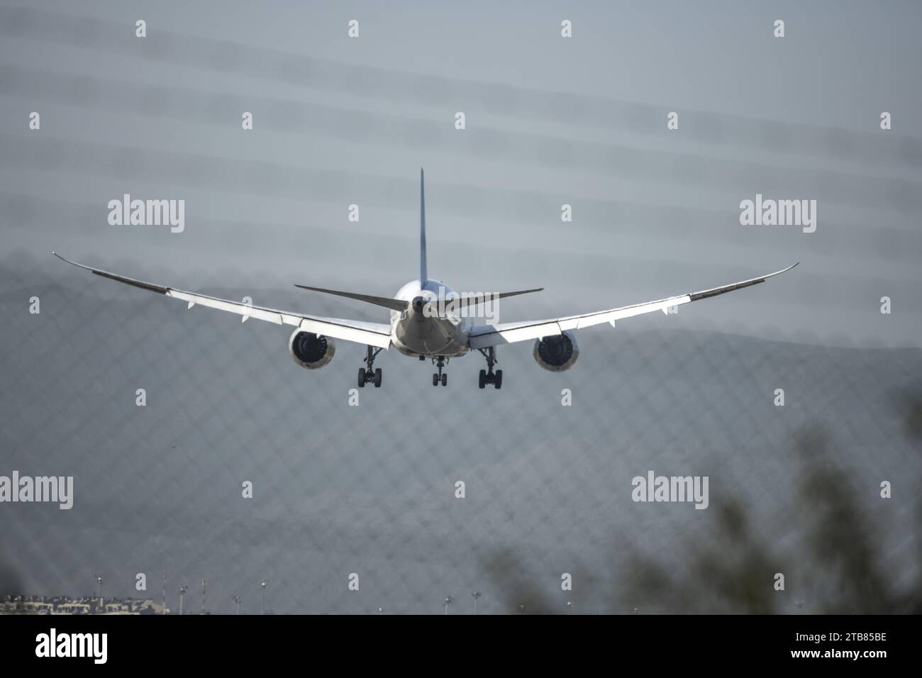 Tail view of a commercial airplane descending to land on the runway ...
