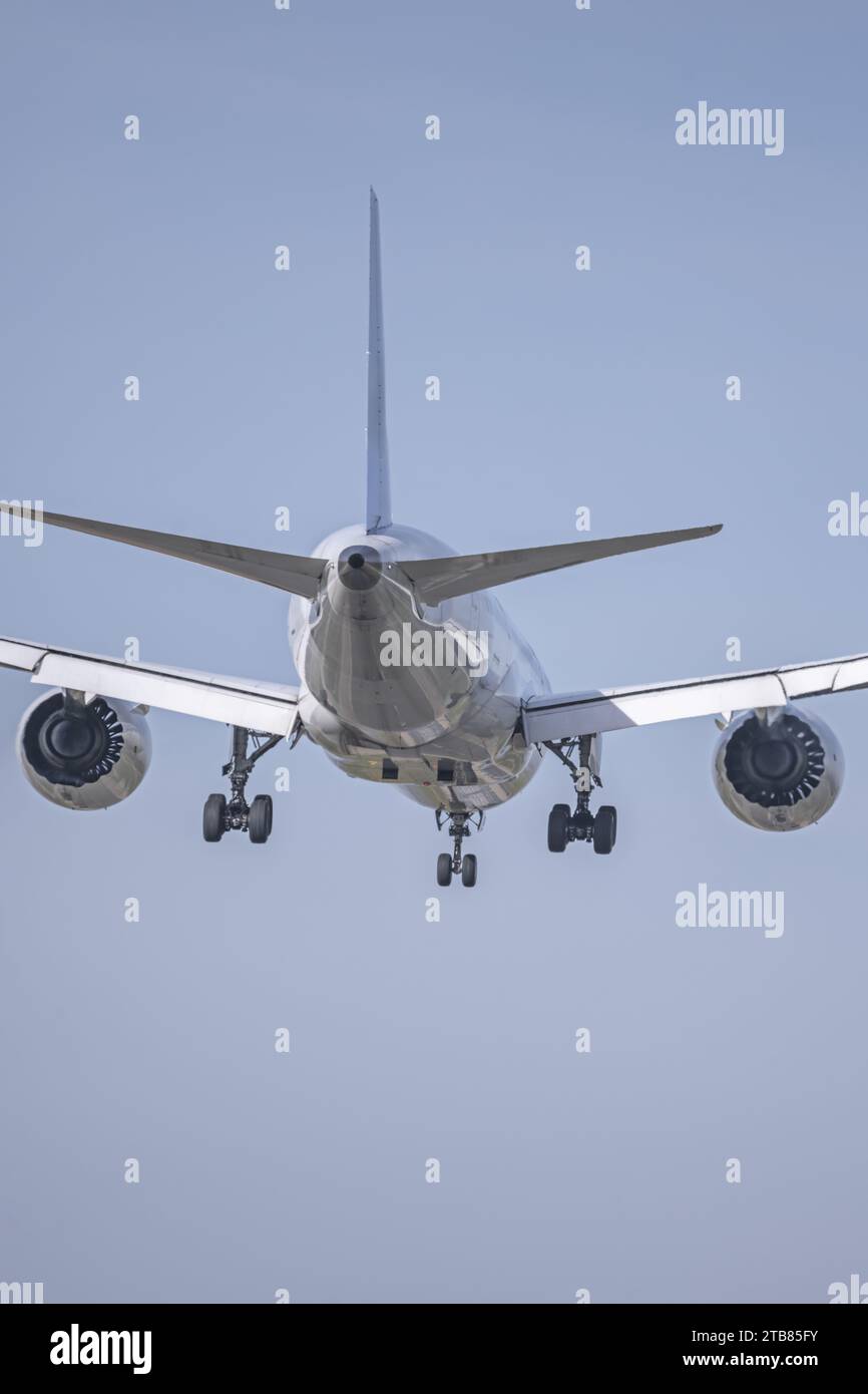 Rear view of a commercial airplane with landing gear deployed ...