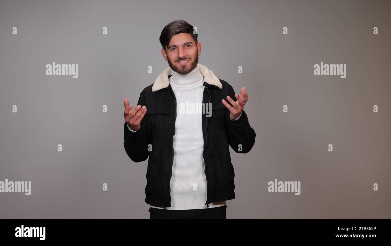 A young man posing with a questioning expression and gesturing "why ...
