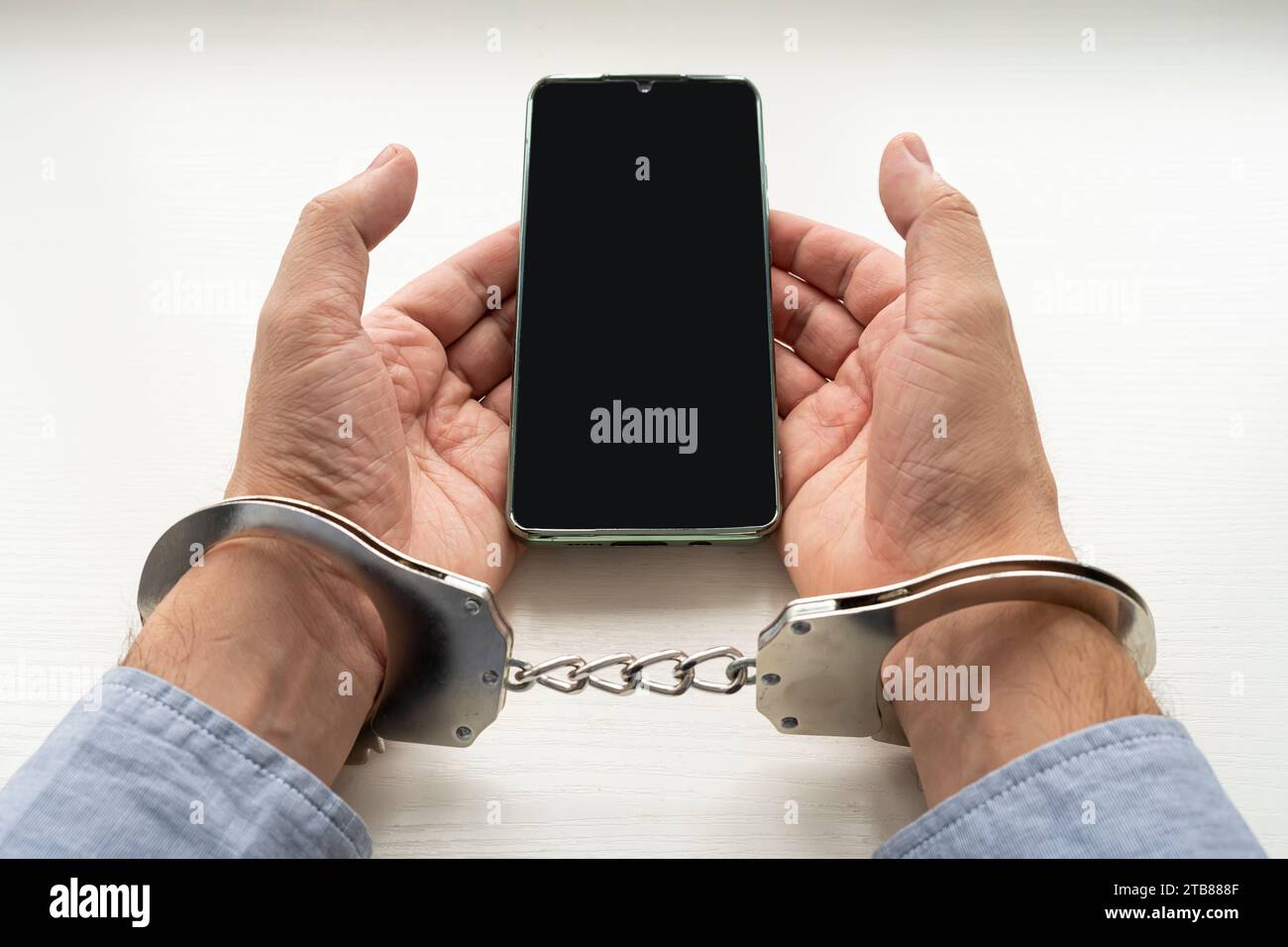 Handcuffs man's hands and mobile phone. Concept of addiction. a phone ...