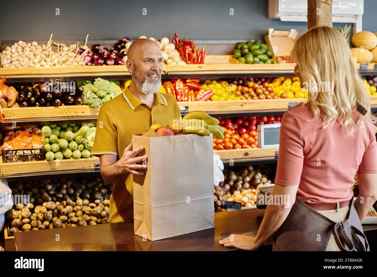 focus on mature customer buying fresh fruits and smiling at blurred ...