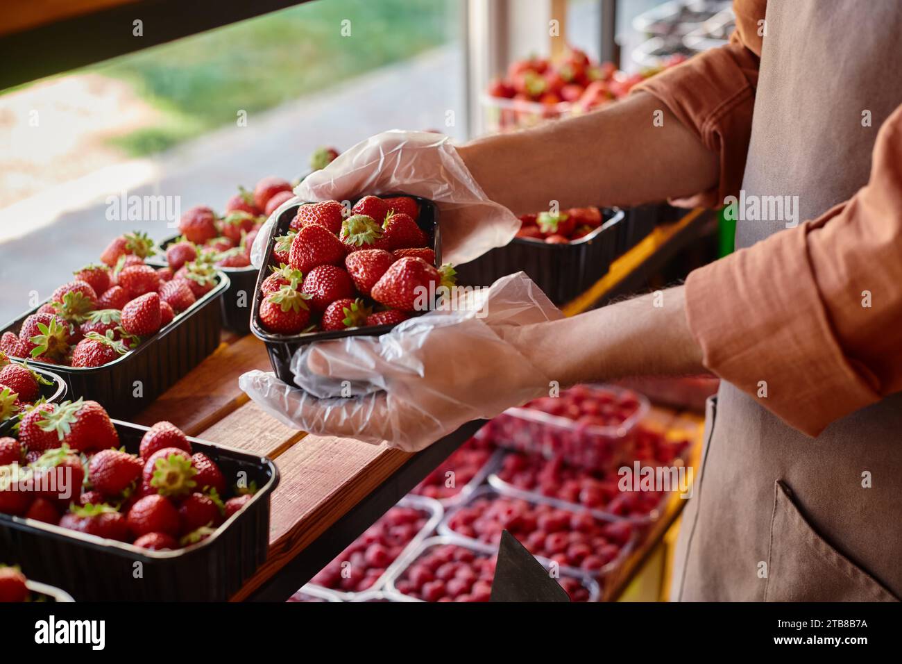 cropped view of mature salesman holding pack of fresh vibrant ...