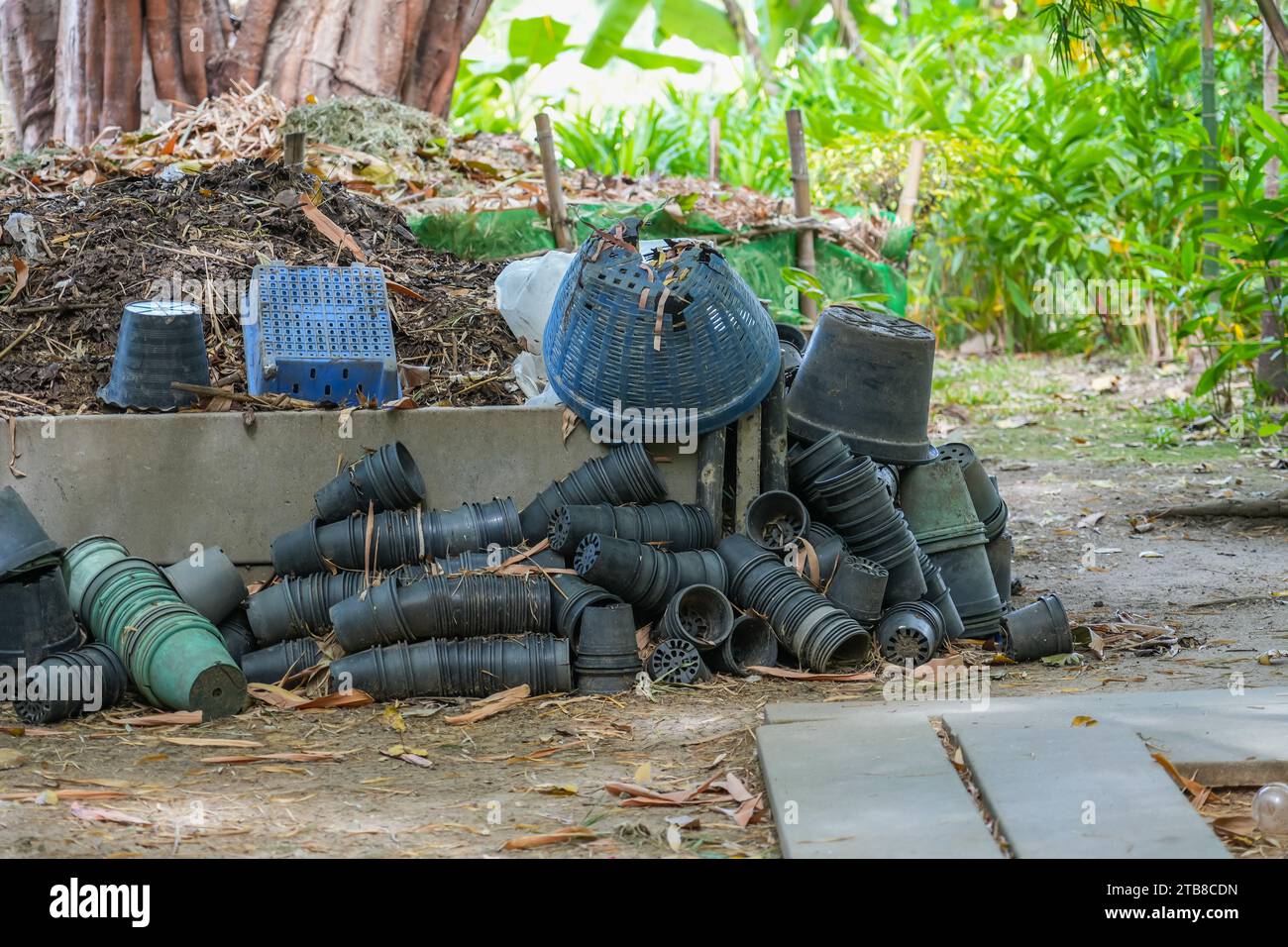 Heap of waste garbage dump with pots and leaves of dried plants in ...