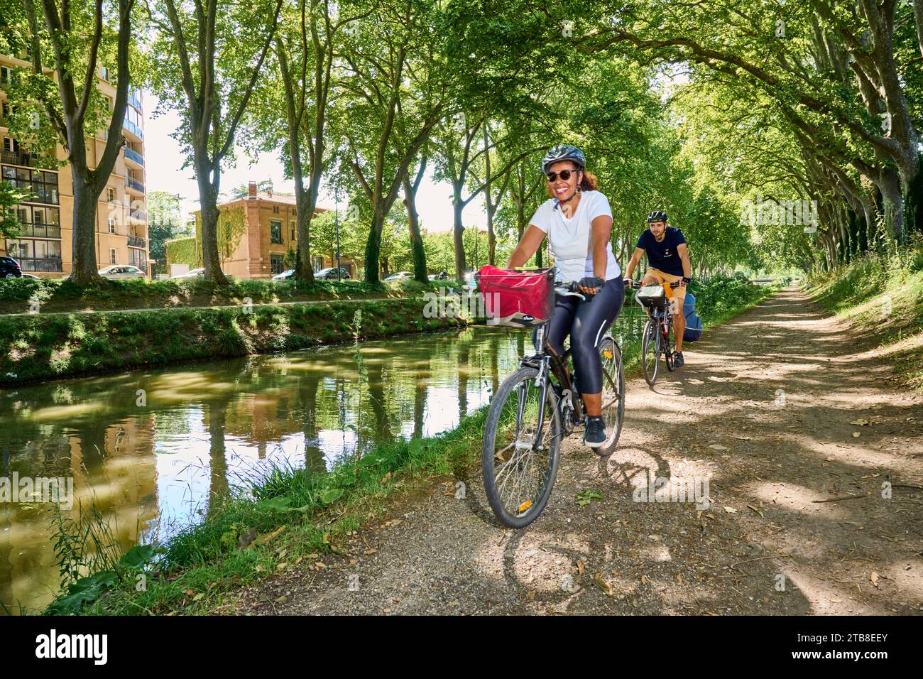 Toulouse (south of France): family bike ride in the shade of the trees ...
