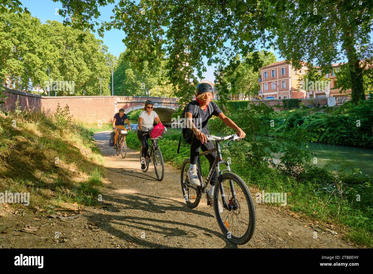 Toulouse (south of France): family bike ride in the shade of the trees ...