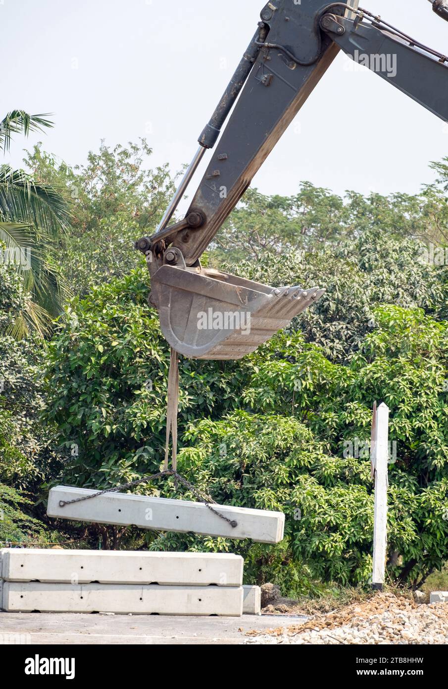 Backhoe is working by lifting cement block in construction site Stock ...