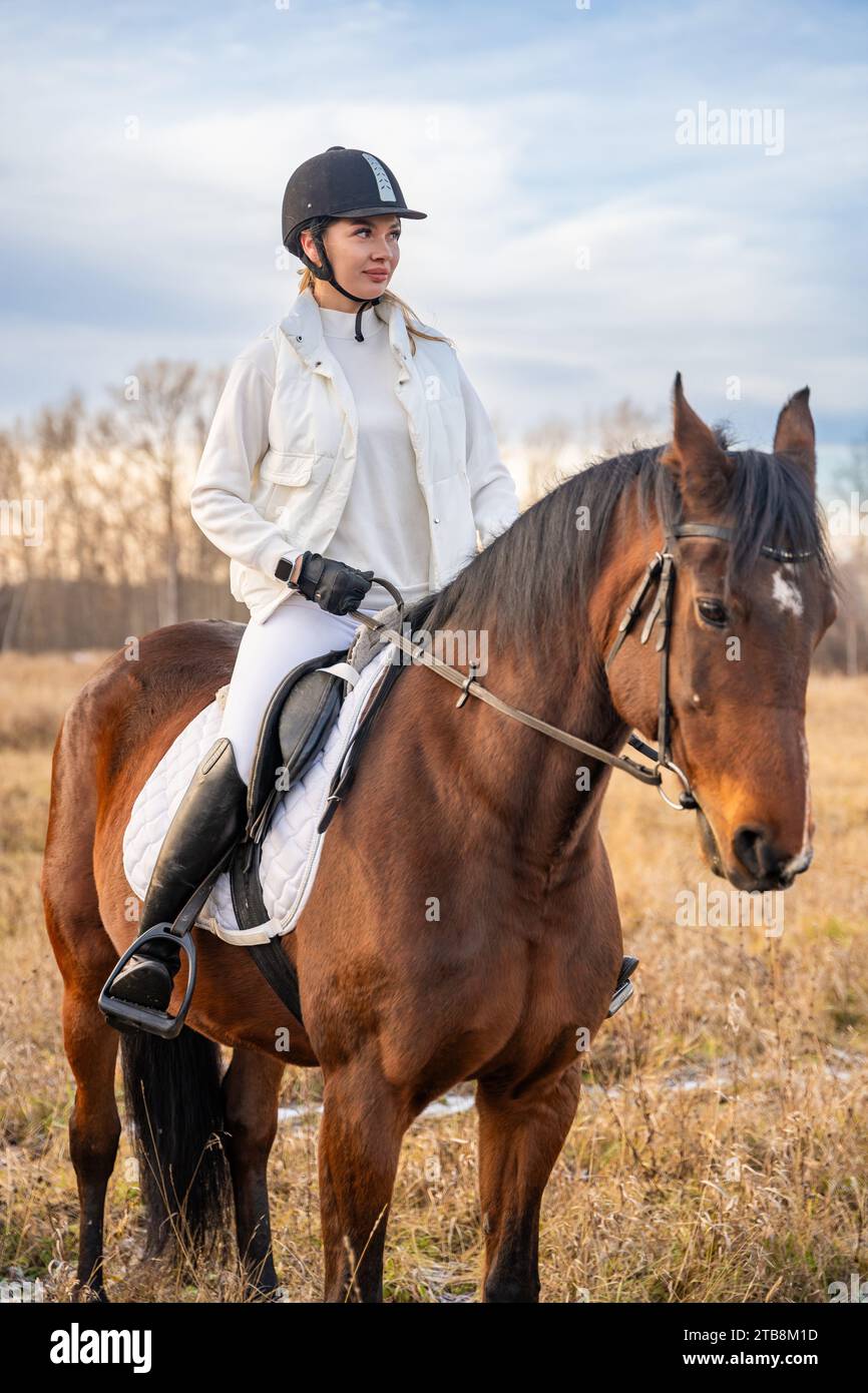 Beautiful blond professional female jockey riding a horse Stock Photo ...