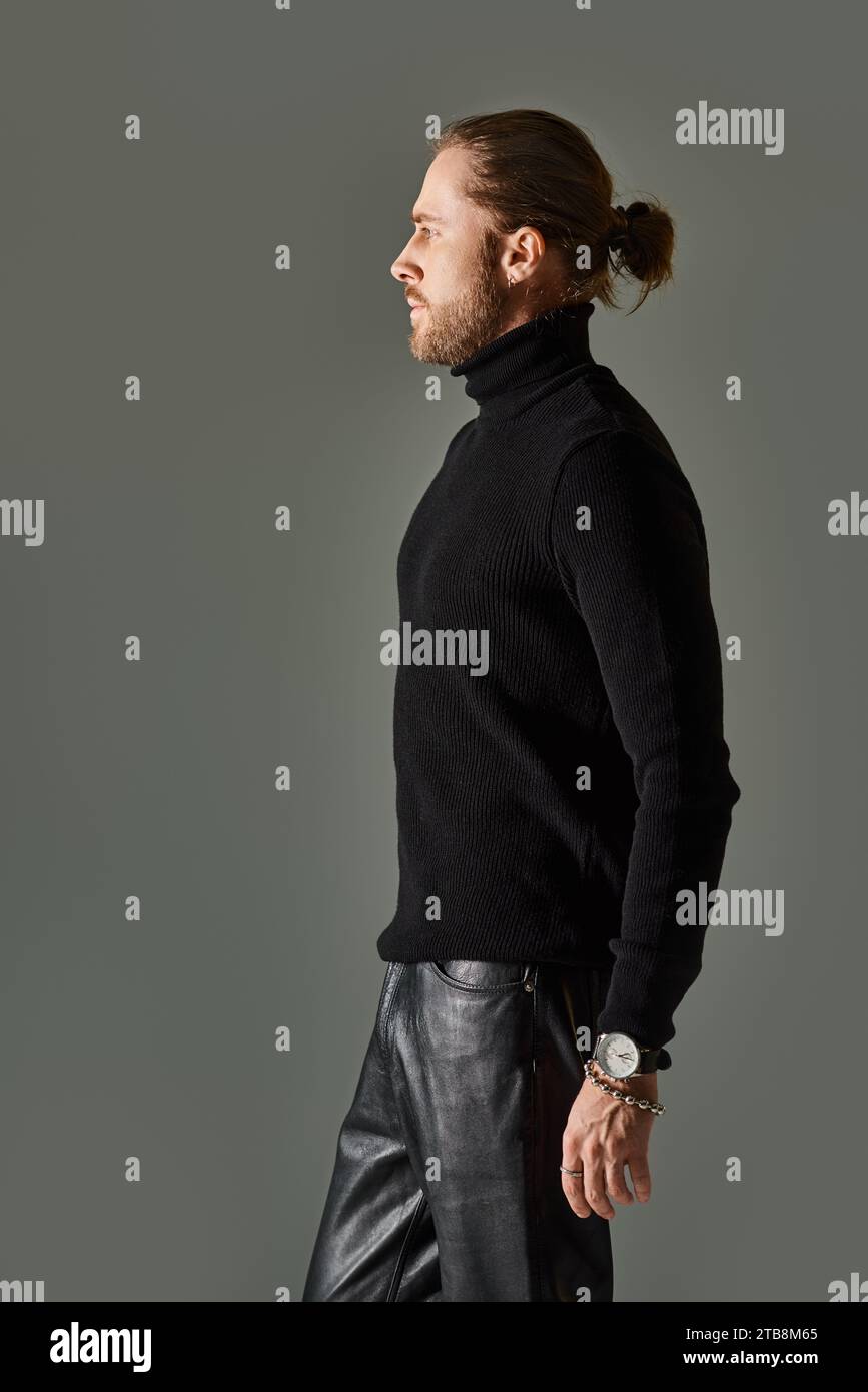 side view of handsome man in turtleneck sweater and leather pants ...