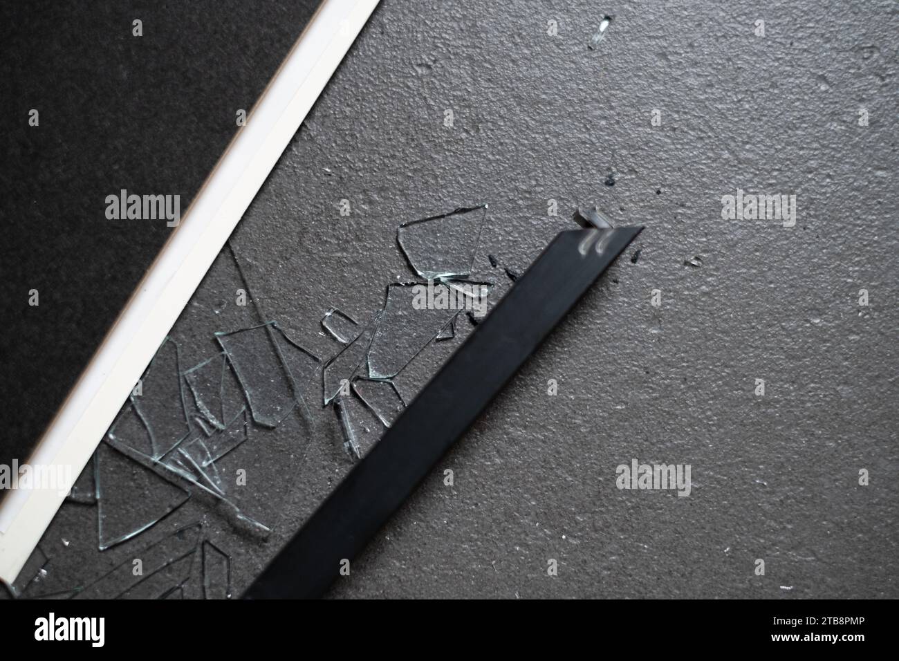 A broken picture frame on a tiled floor, with the frame itself broken ...