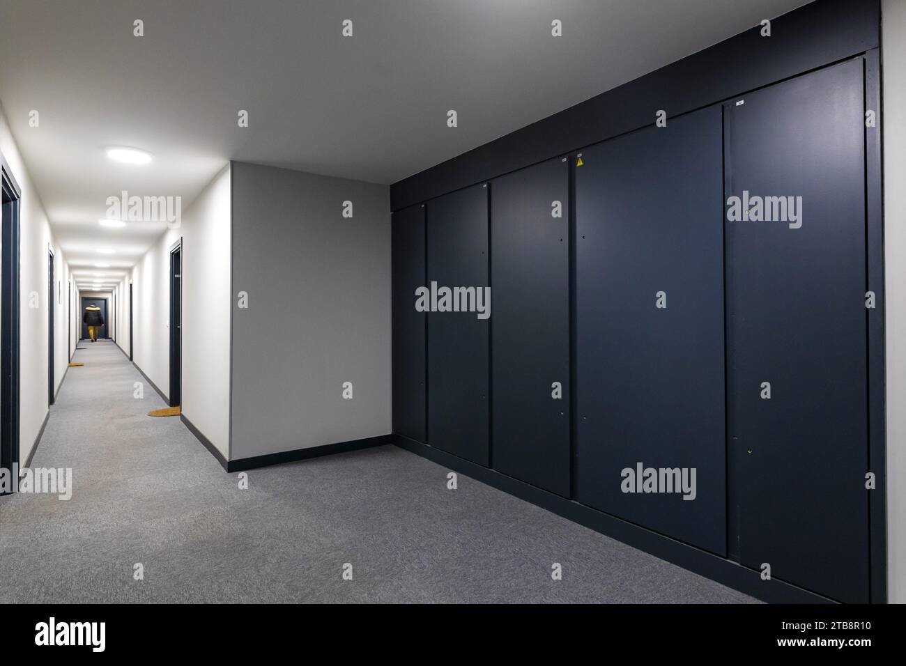 Interior of a new building. First-floor corridor with access doors to ...