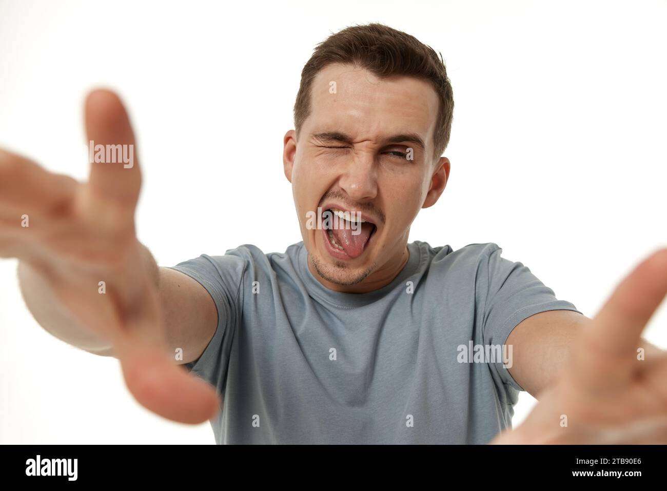 portrait of young happy man winking looking at the camera on white ...