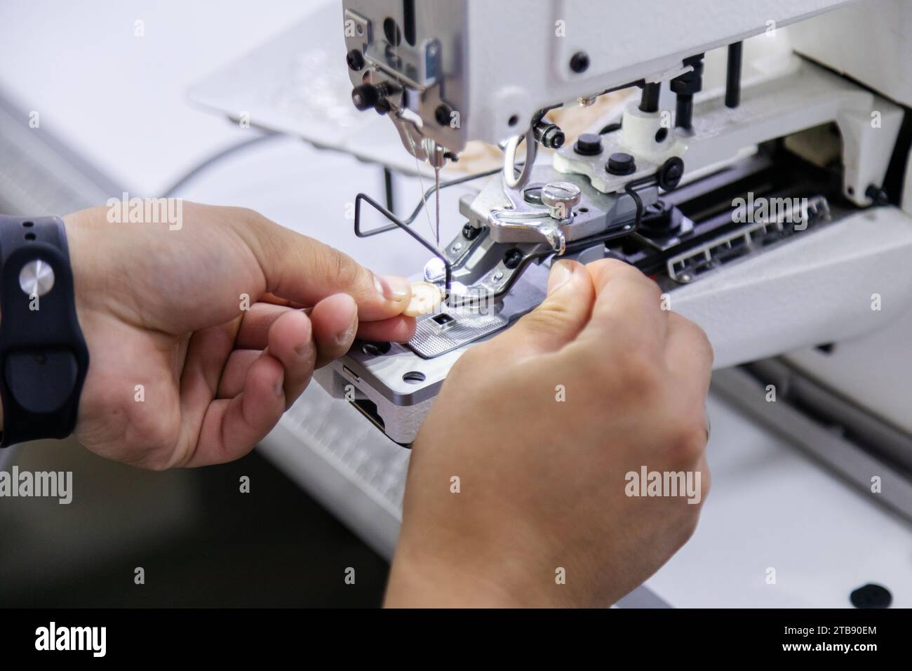 Close up of tailor adding button to electric sewing machine Stock Photo ...