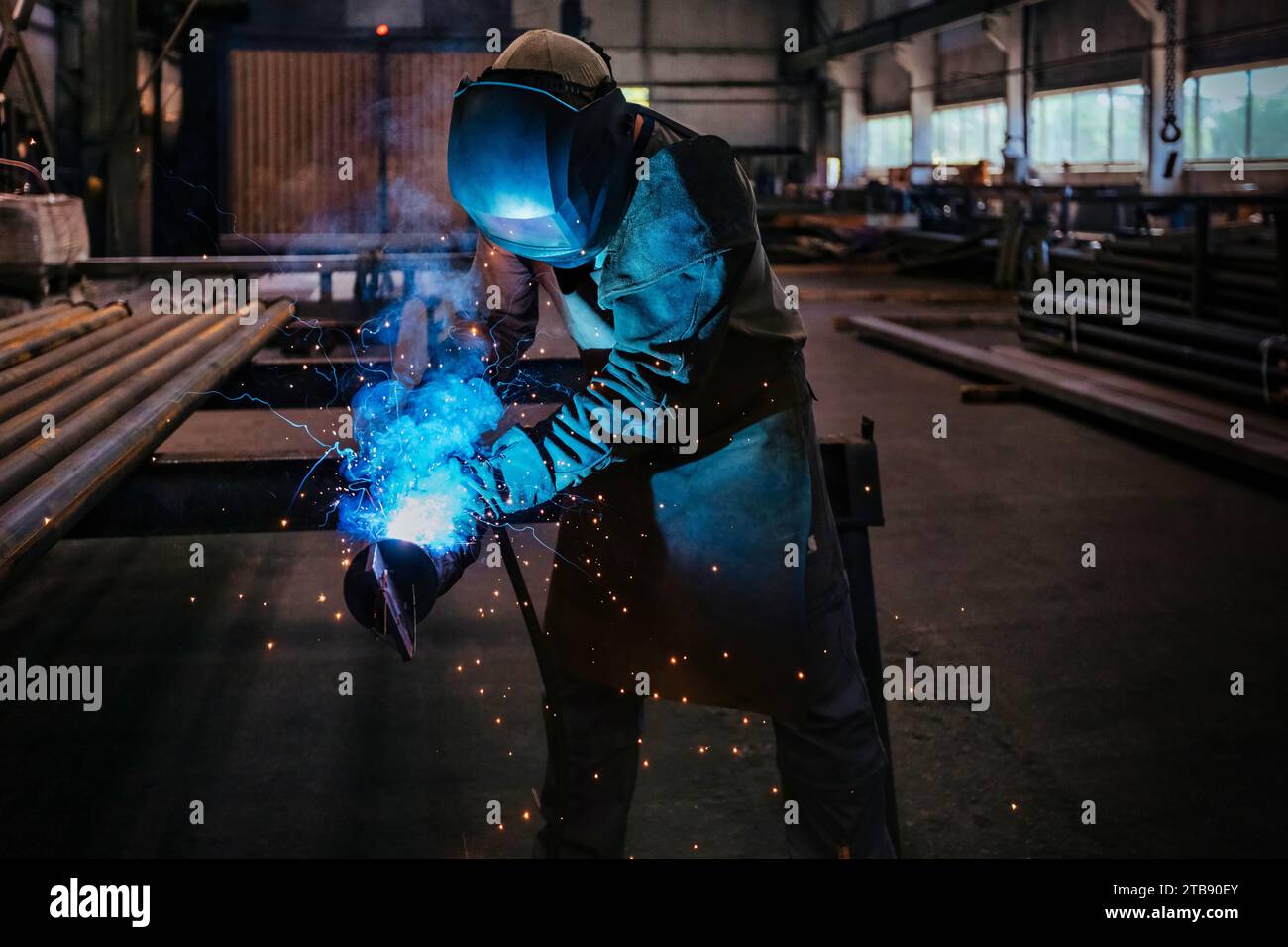 The welder works in the workshop. The moment of welding of metal ...