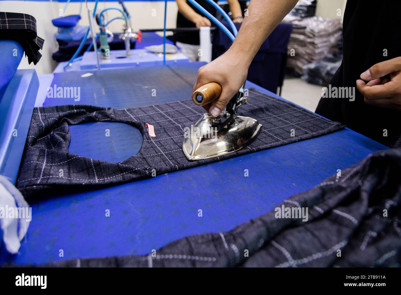 Tailor ironing clothes in tailoring shop with steam Iron Stock Photo ...