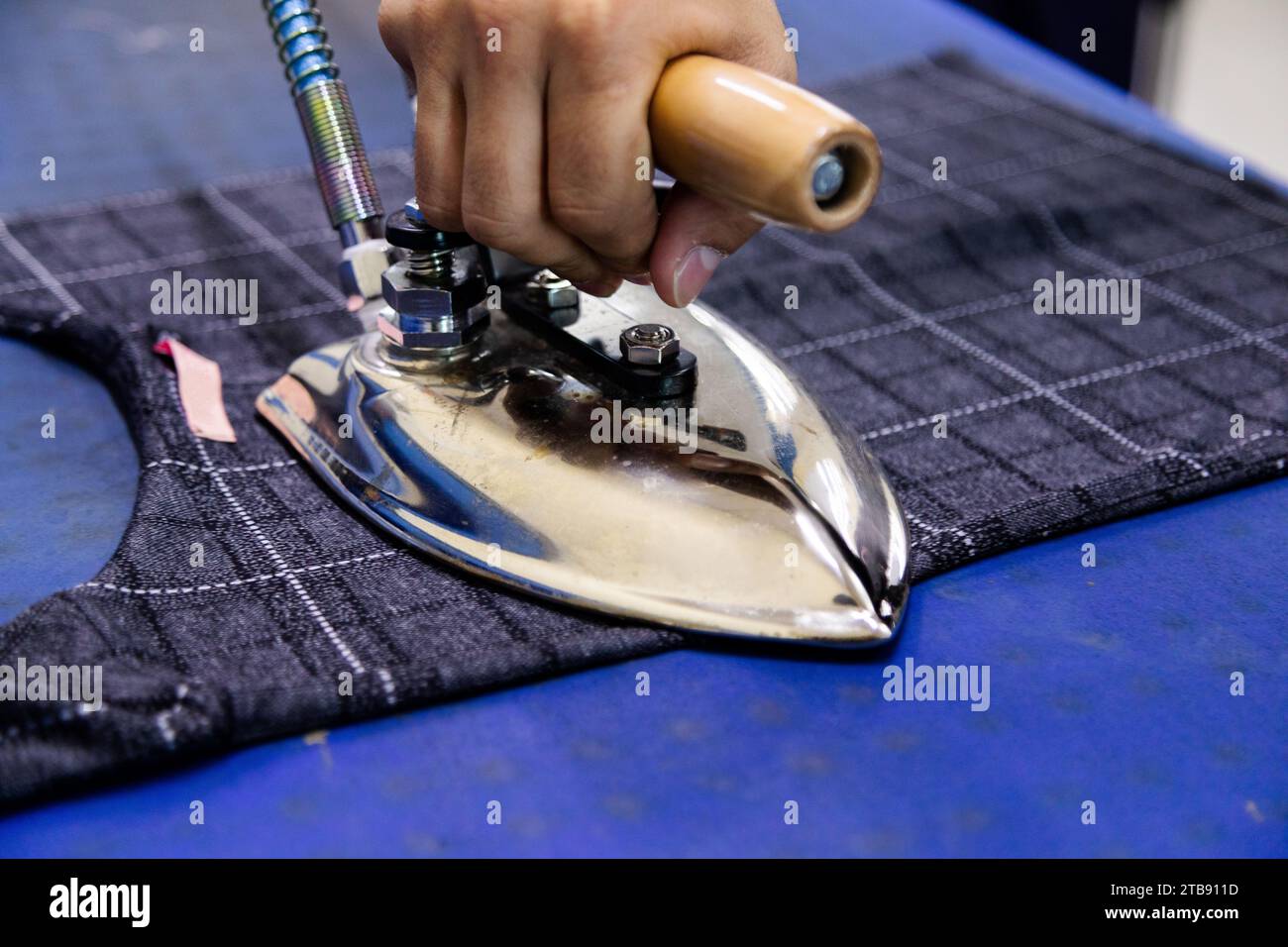 Tailor ironing clothes in tailoring shop with steam Iron Stock Photo ...