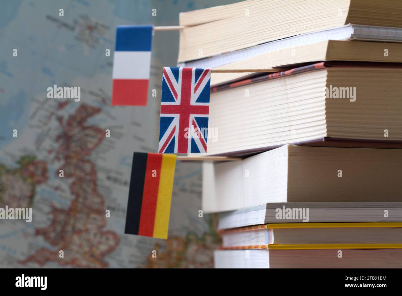 Stack of books with country flags on background of map, foreign ...
